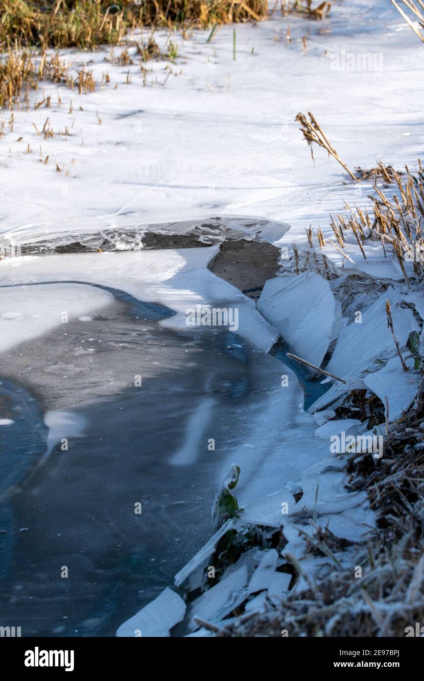 The trench is frozen over and covered with ice. It is winter and severe ...