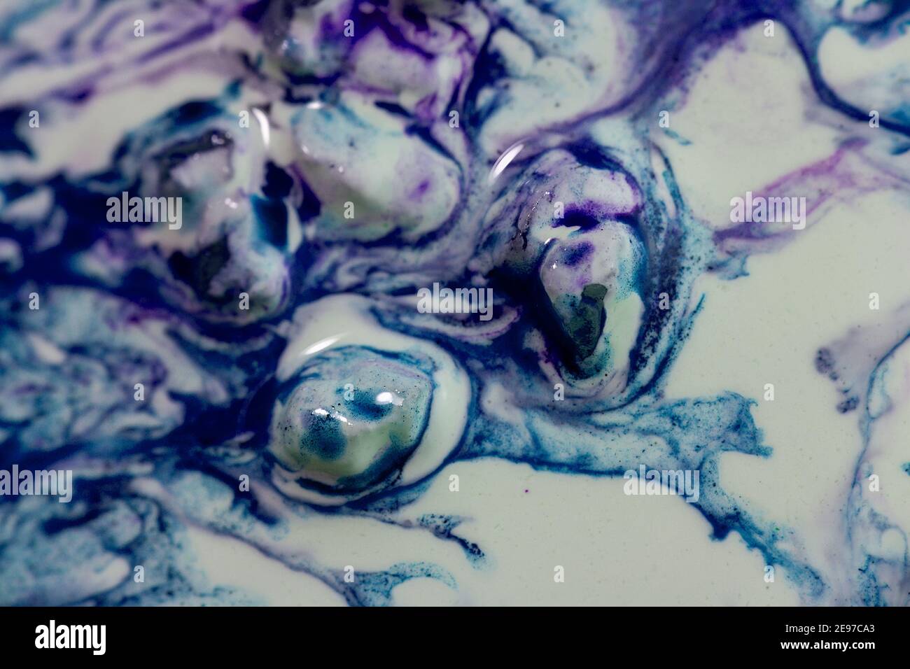 Luqiud vivid blue and violet color mixing together on white background ...