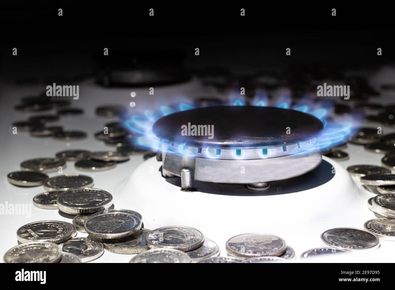 Money and gas burner on a white background with space for text. The ...
