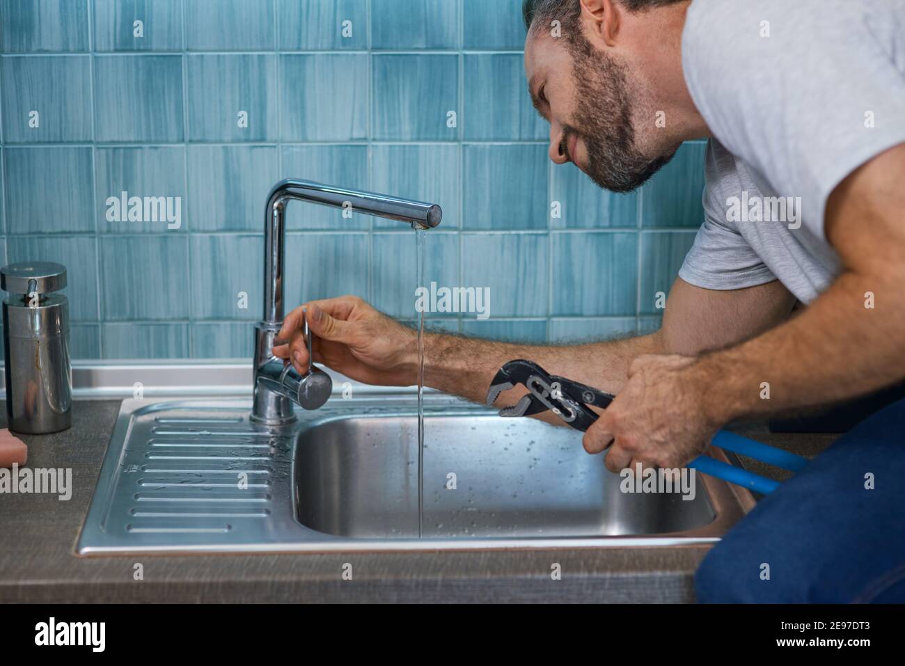 Fix a leak. Close up shot of professional repairman using pipe wrench ...