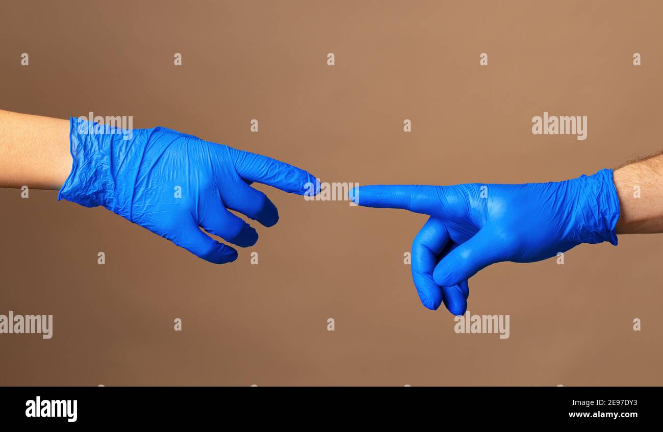 Male and female hands in medical gloves stretch to each other. Help ...