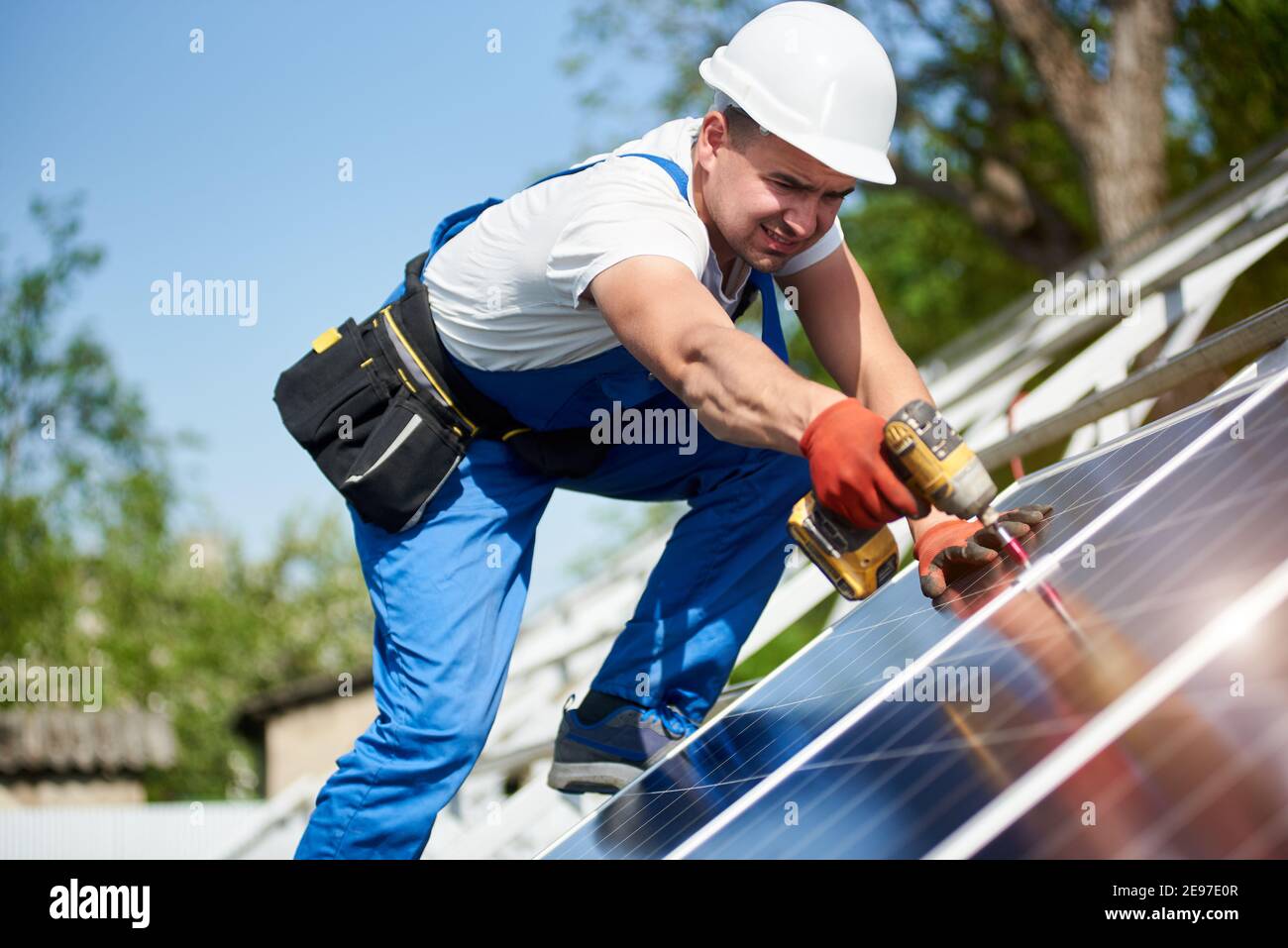 Technician connecting solar photo voltaic panel to metal platform using ...