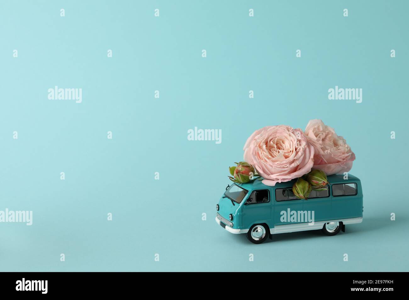 Toy bus with pink roses on blue background Stock Photo - Alamy