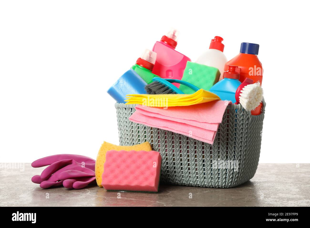 Group of cleaning tools on gray table isolated on white background ...