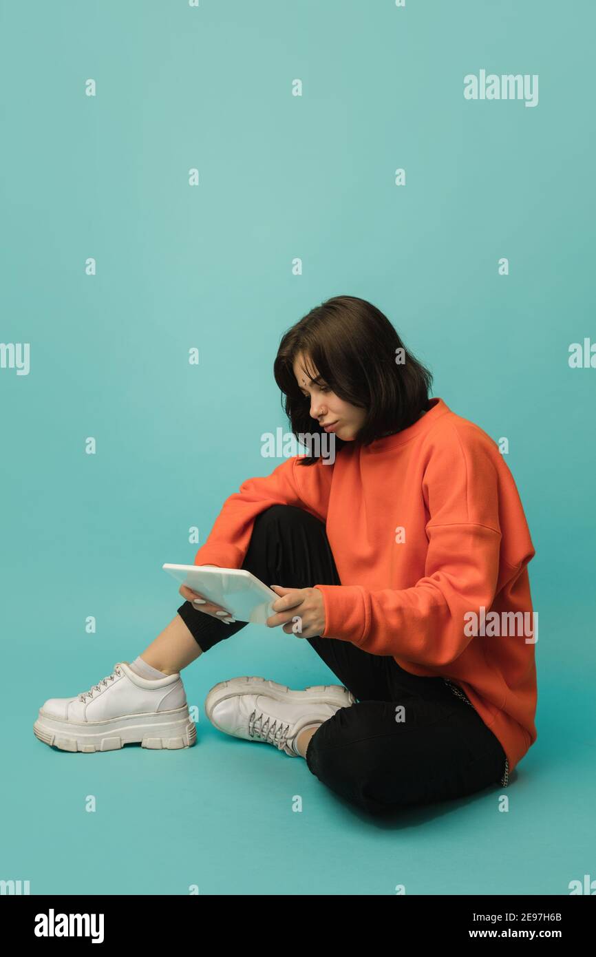 Scrolling tablet. Caucasian woman's portrait isolated on blue ...