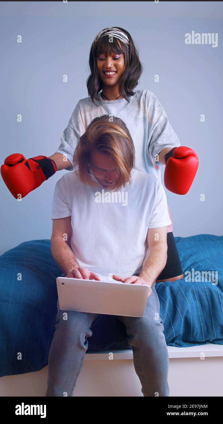 Woman with boxing gloves playing with boyfriends long hair trying to ...