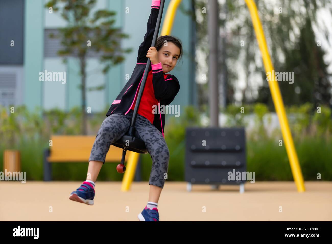 The little girl on the bungee jumping for kids outdoor Stock Photo - Alamy