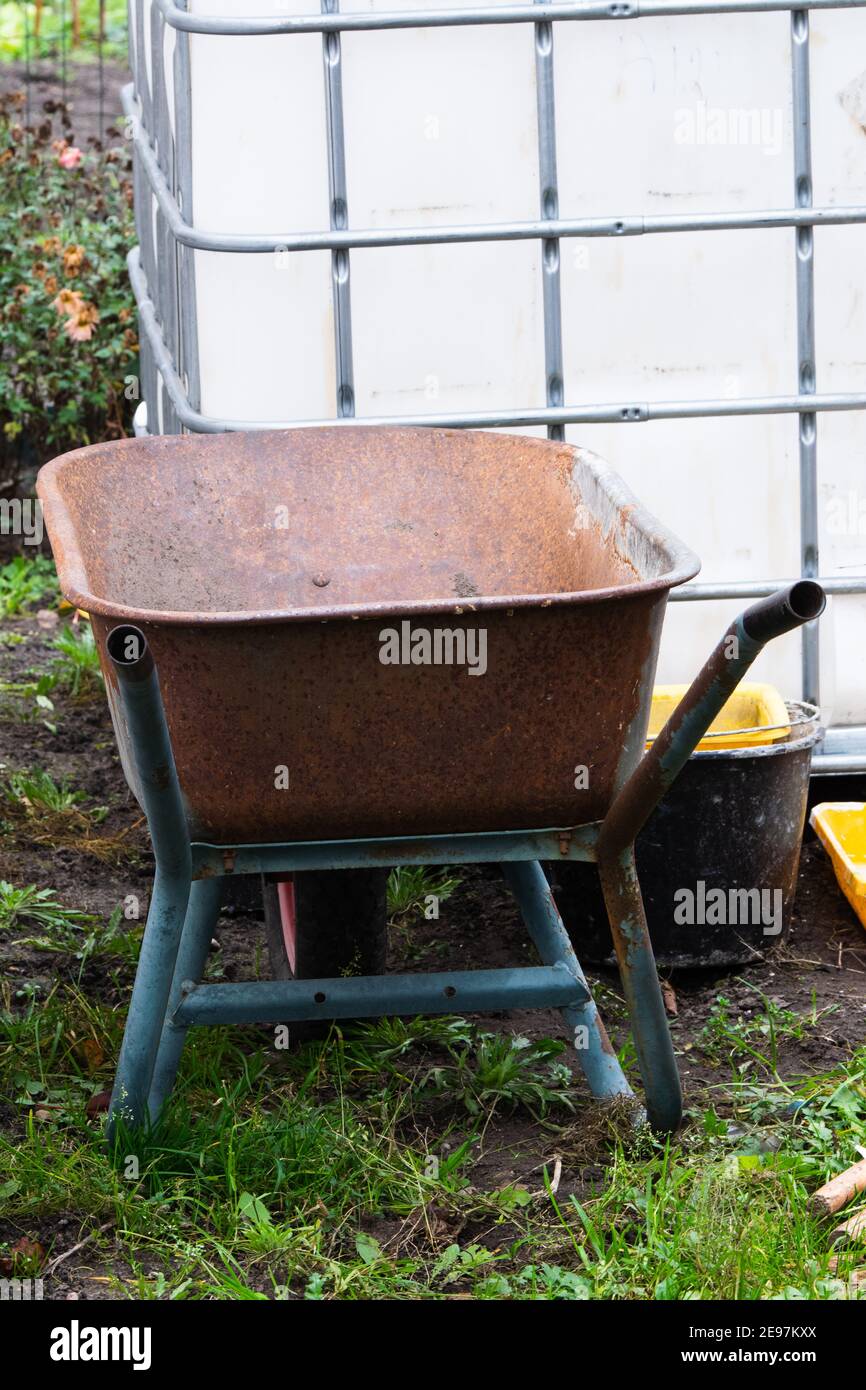 Abandoned rusty wheelbarrow in abandoned garden Stock Photo - Alamy