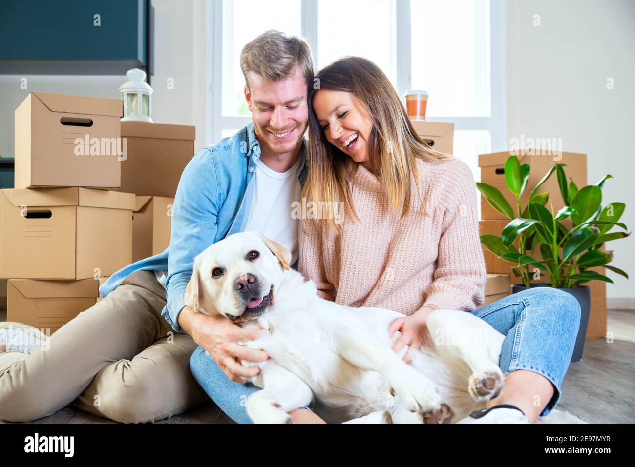 Husband and wife and their dog moving in new home - Young couple just ...