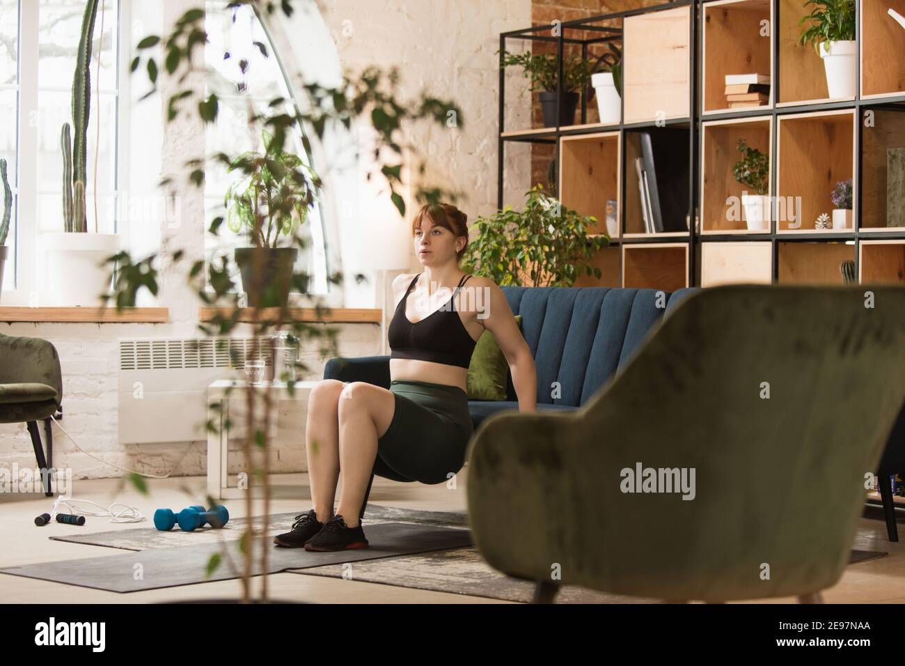 Woman squats sofa hi-res stock photography and images - Alamy