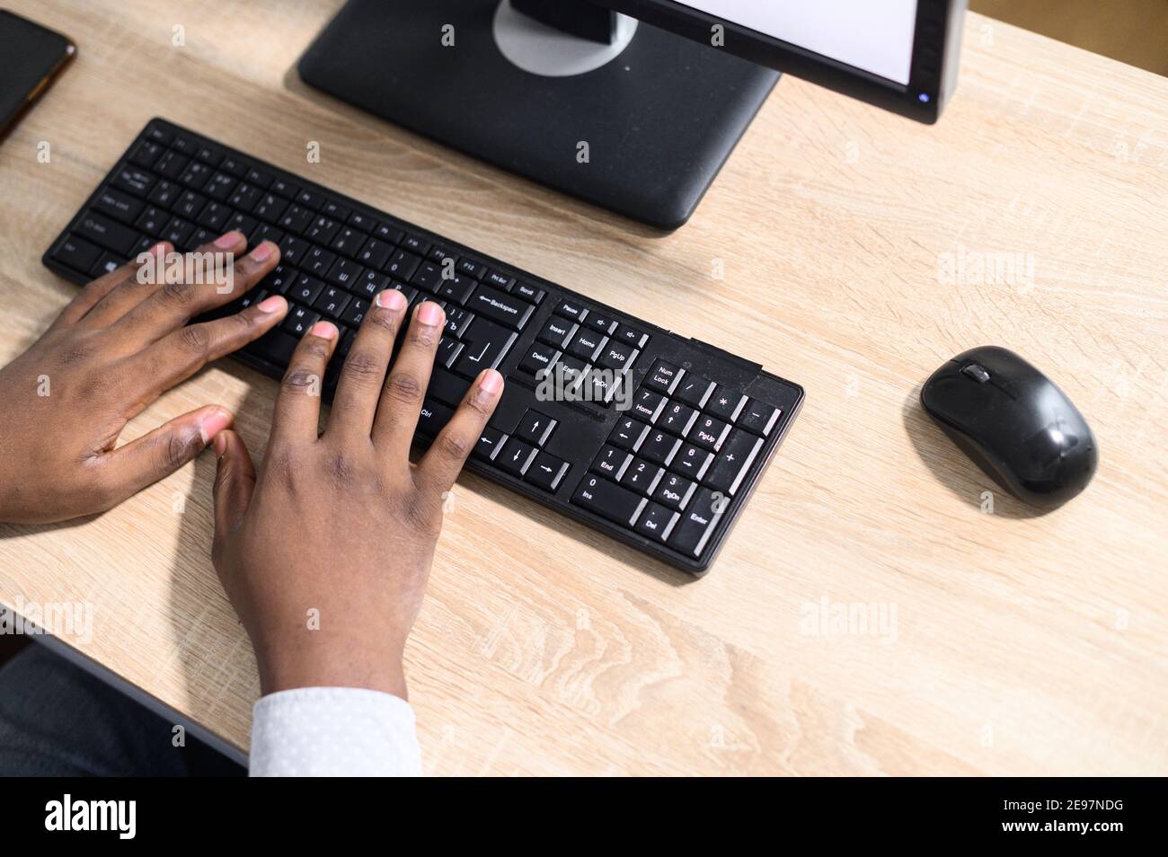 Top view hands of an African-American guy typing on the laptop keyboard ...