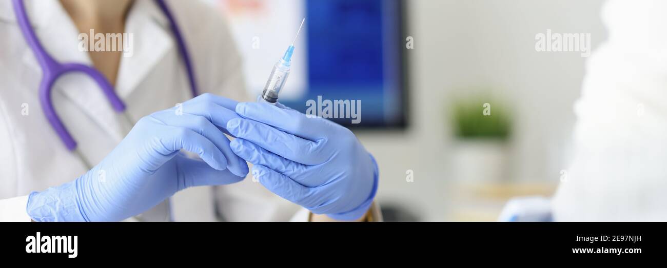 Doctor's hands hold syringe with needle next to the patient Stock Photo ...
