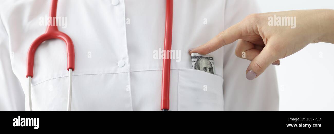 Banknote is thrust into doctor's pocket closeup Stock Photo - Alamy