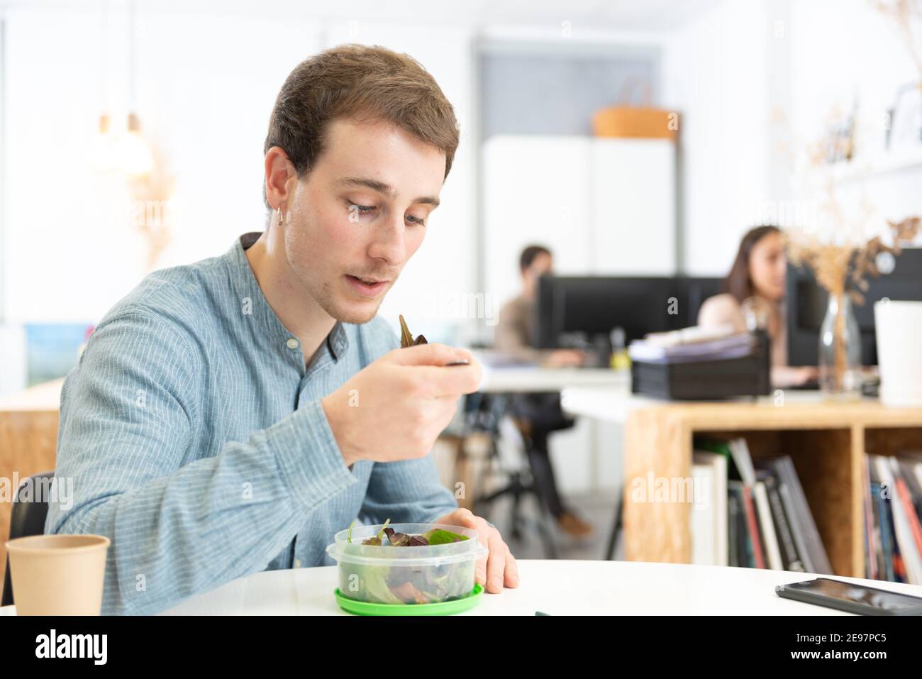 Healthy food in the workplace concept. Handsome worker having a lunch ...