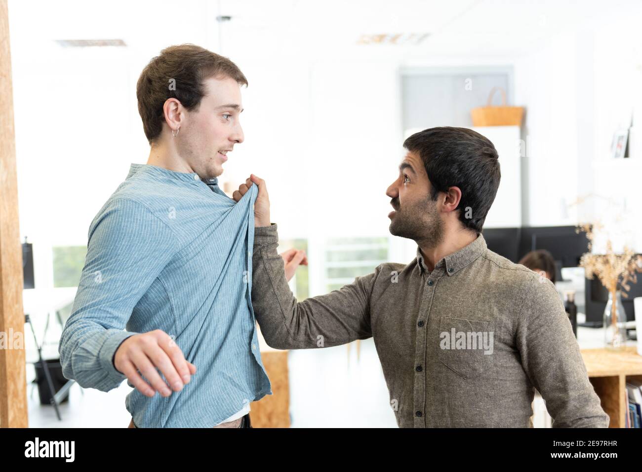 Angry hispanic man fighting and threatening a frightened caucasian ...