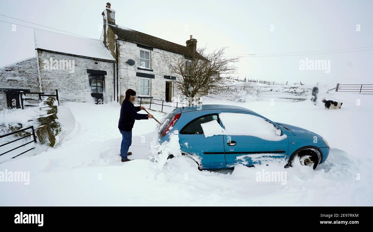 Johan Brand clears the snow from her car in the village of Harwood in ...