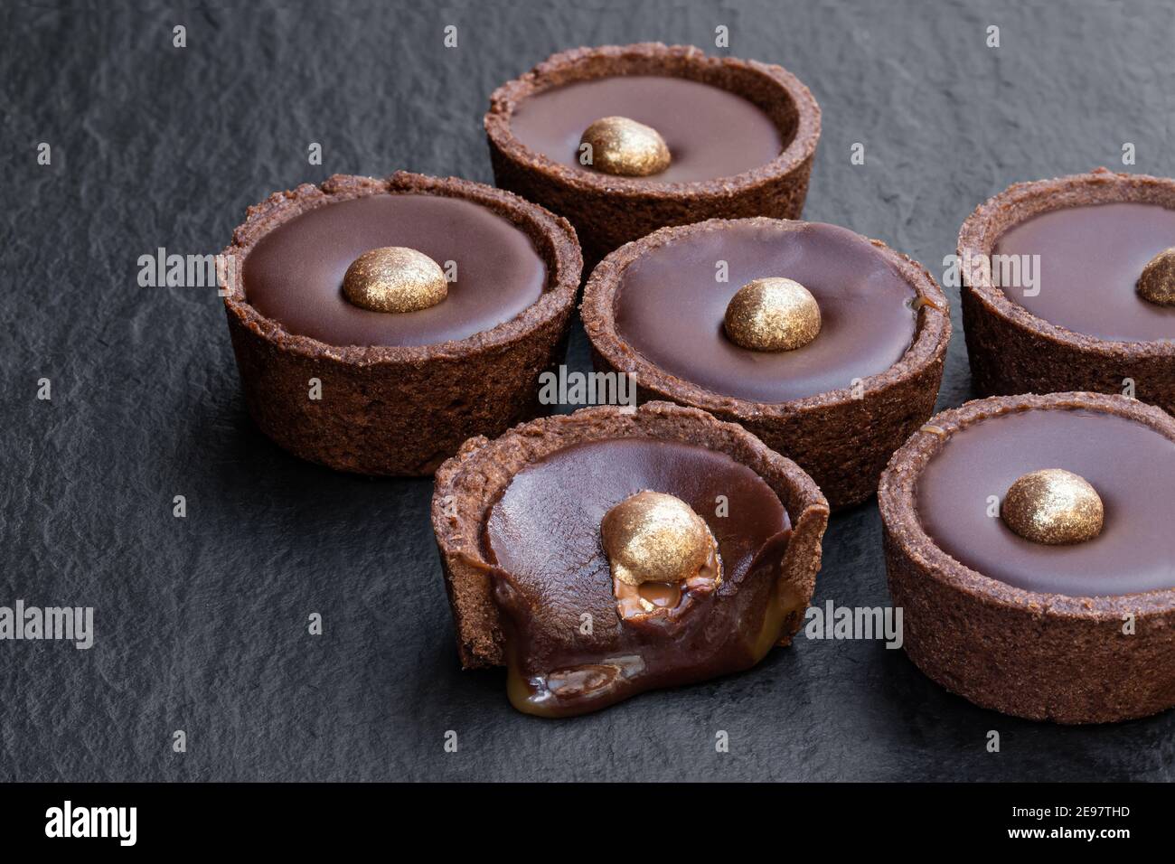 Molten Chocolate Caramel truffles decorated with golden drip on stone ...