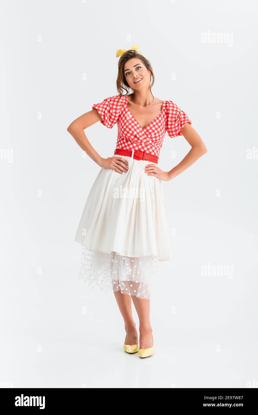 cheerful pin up woman posing with hands on hips on white Stock Photo ...