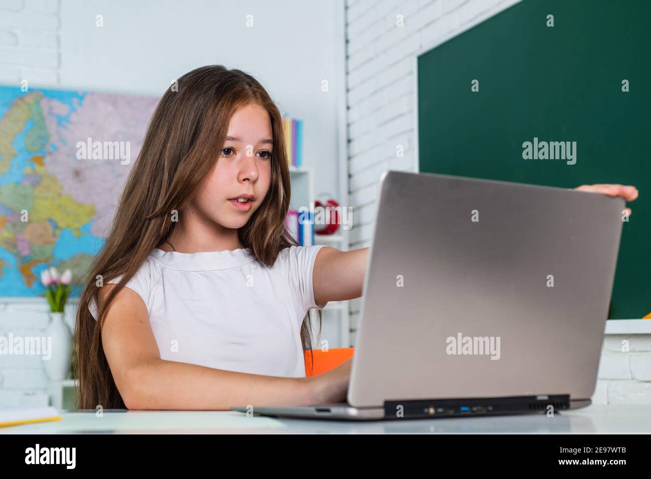 cheerful kid girl with computer at school lesson, e learning Stock ...