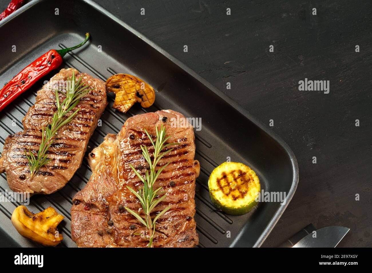 Beef steaks with vegetables on grill pan Stock Photo - Alamy