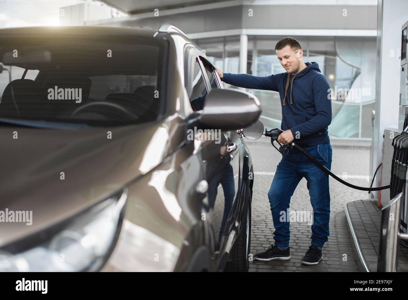 Petrol station, auto fueling concept. Portrait of young handsome ...