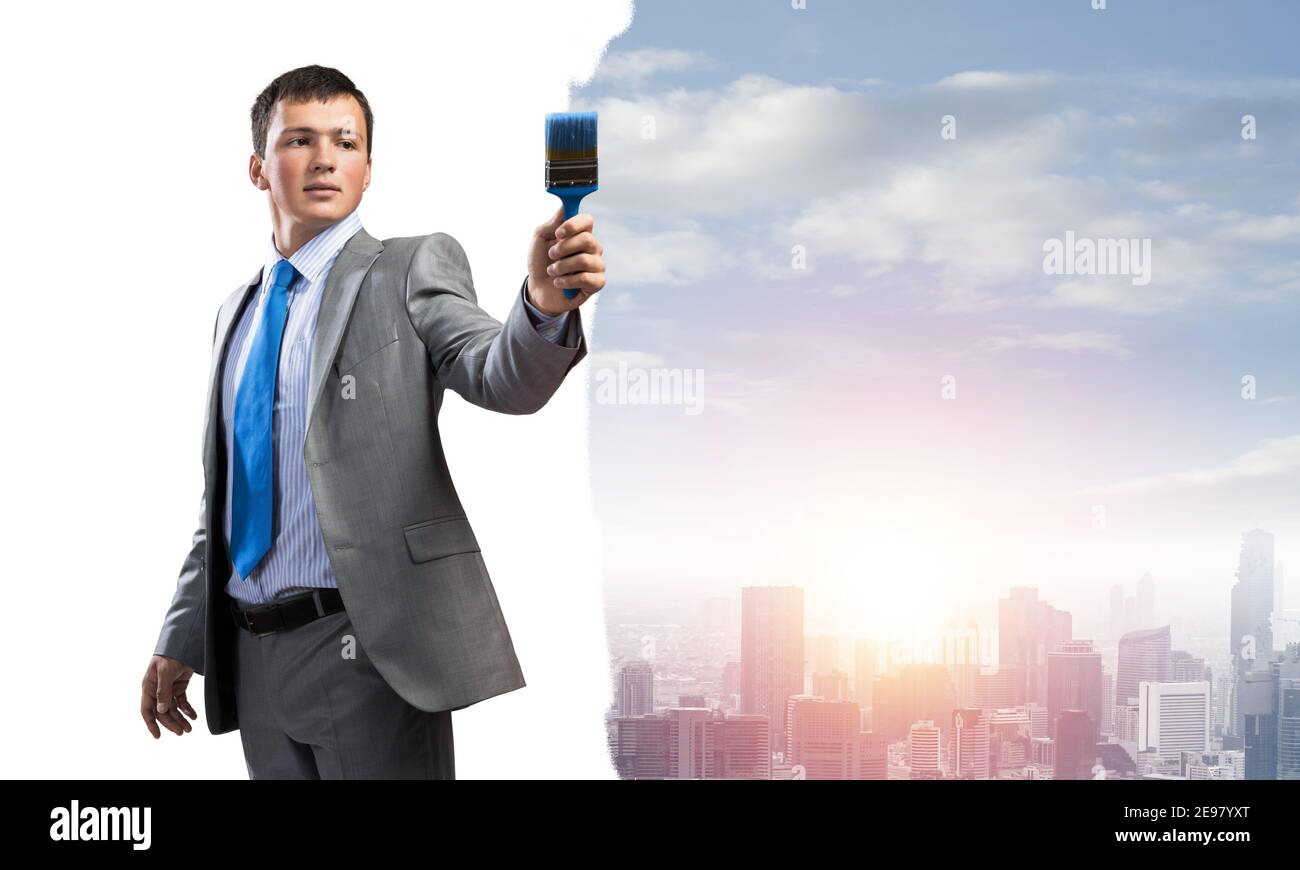 Creative businessman painter holding paintbrush Stock Photo - Alamy