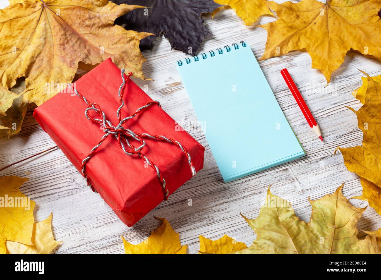 Spiral notepad with pen and gift box on desk Stock Photo - Alamy
