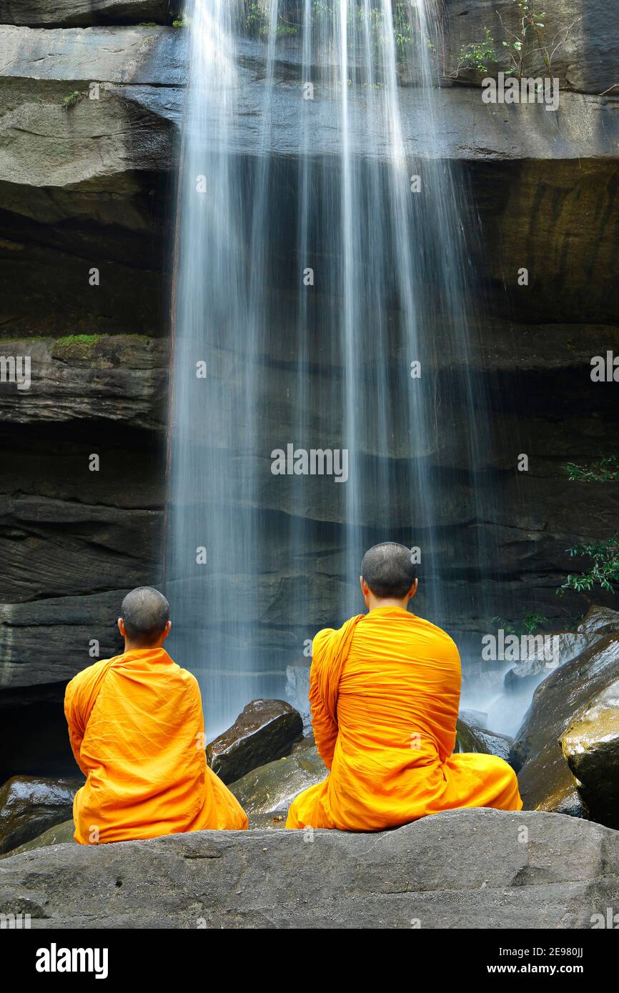 Monk doing meditation in front of a waterfall in thailand Stock Photo ...