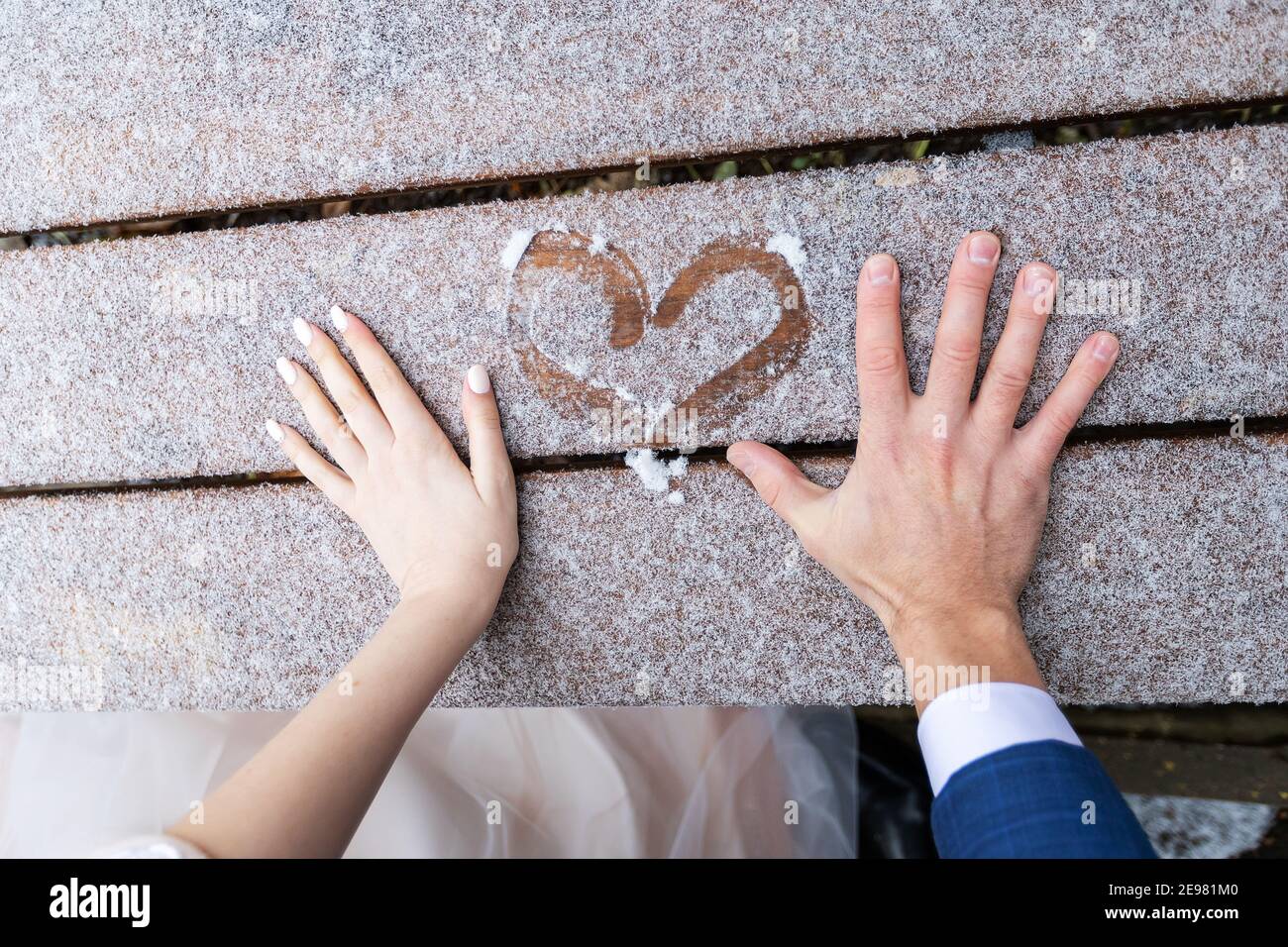 two lovers draw with their fingers in the snow, draw hearts in the snow ...