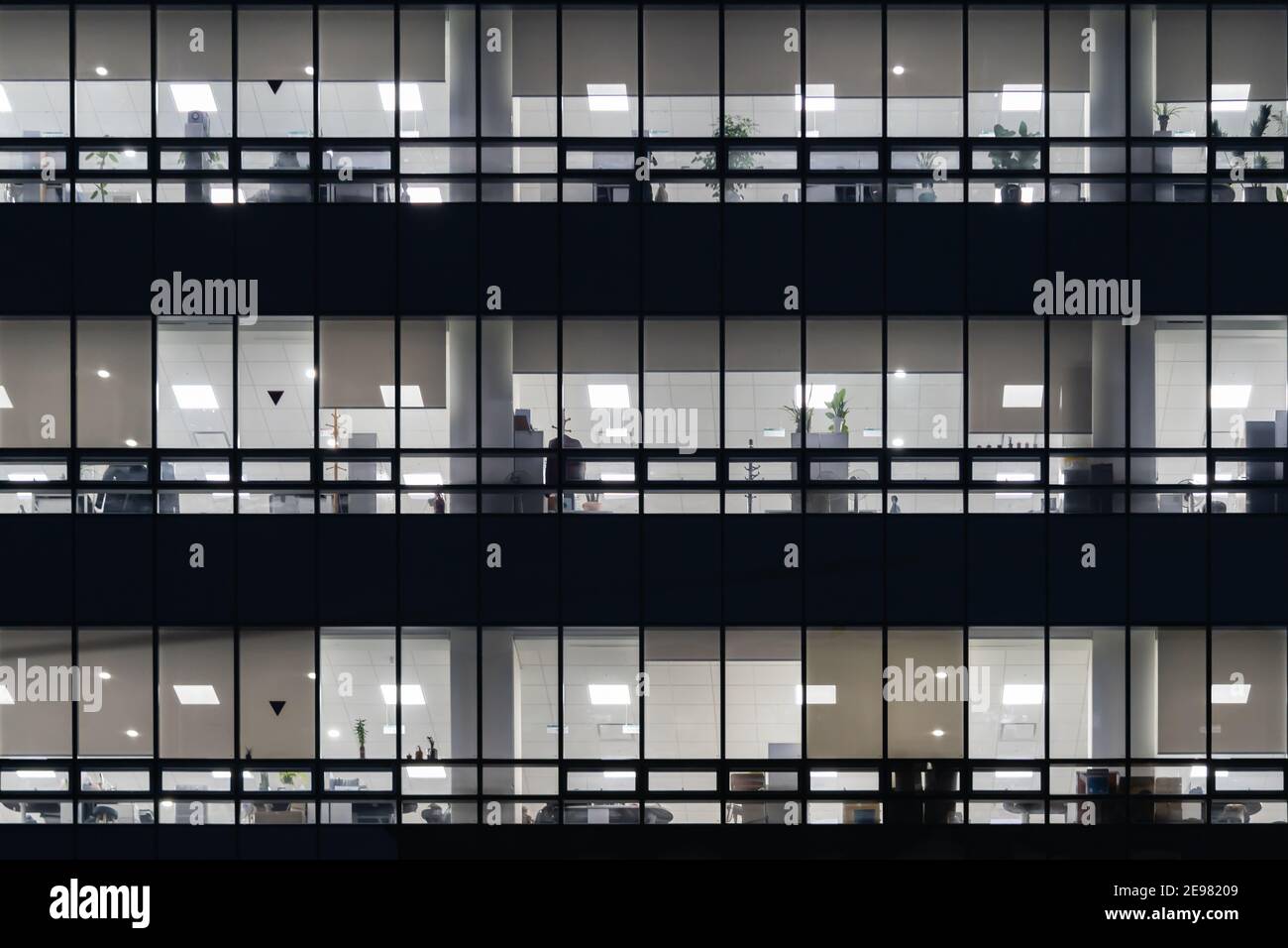 The windows of a modern office building with lights inside at night ...
