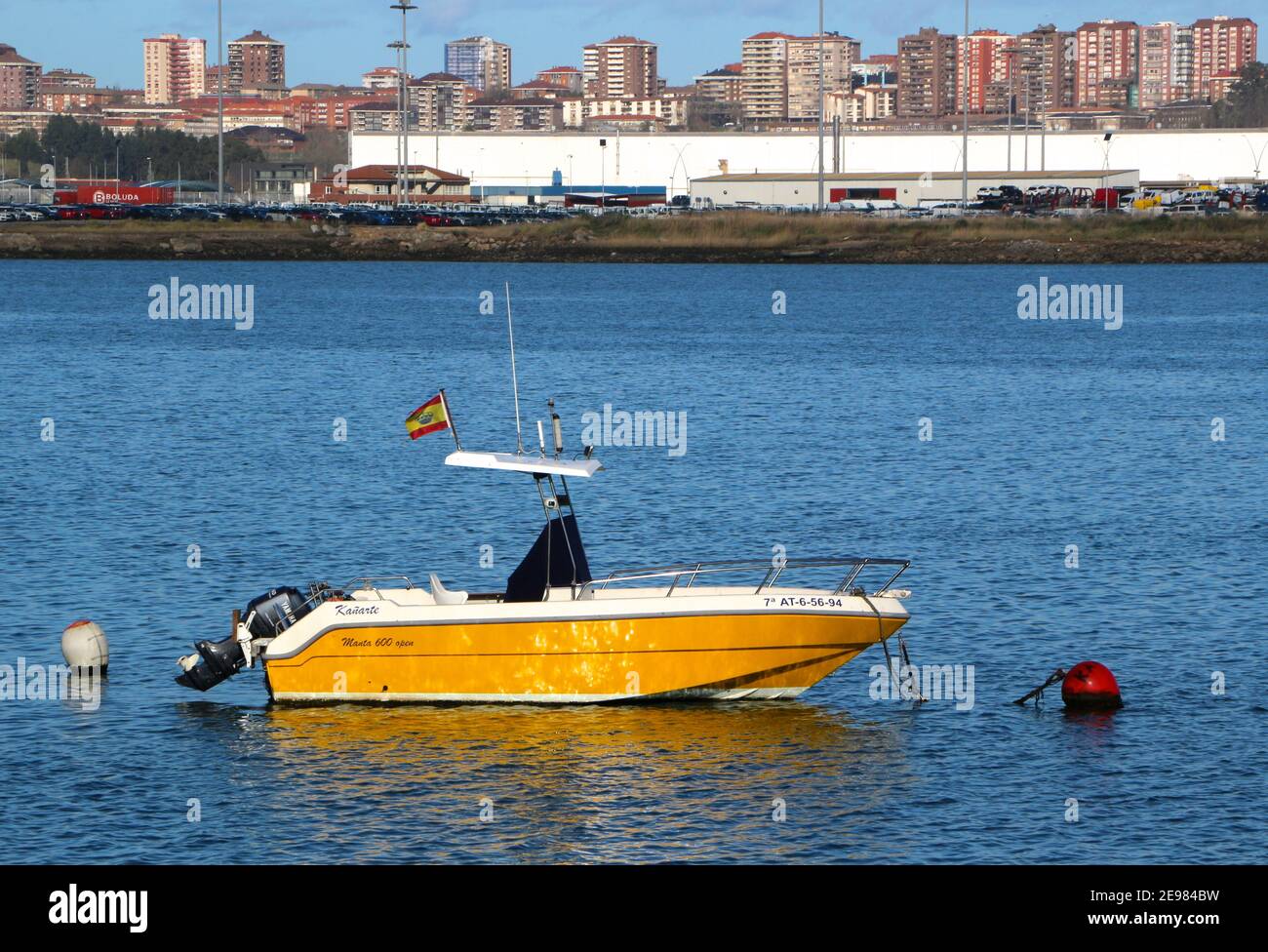 Small yellow motor boat with an outboard motor moored to a red mooring ...