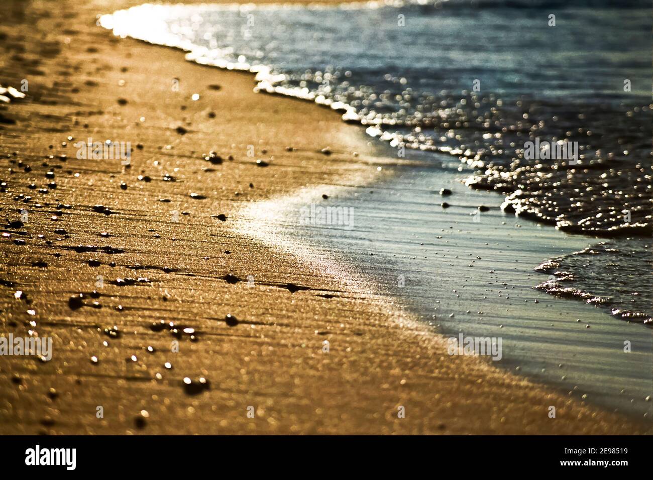 Beach, sand and water in the setting sun Stock Photo - Alamy