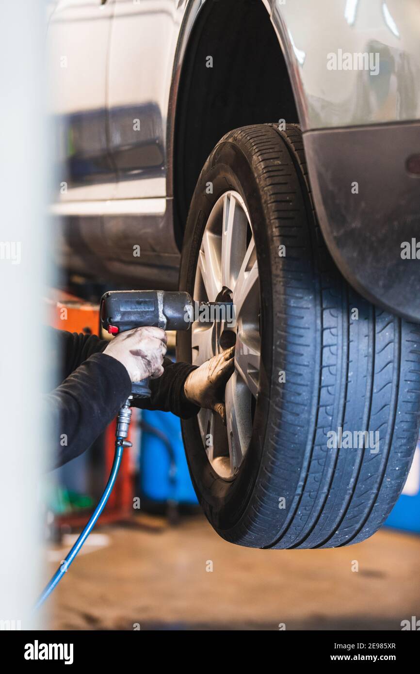 Mechanic changing car wheel in auto repair shop Stock Photo - Alamy