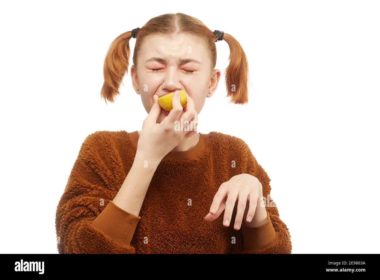 Young woman eating lemon grimace hi-res stock photography and images ...