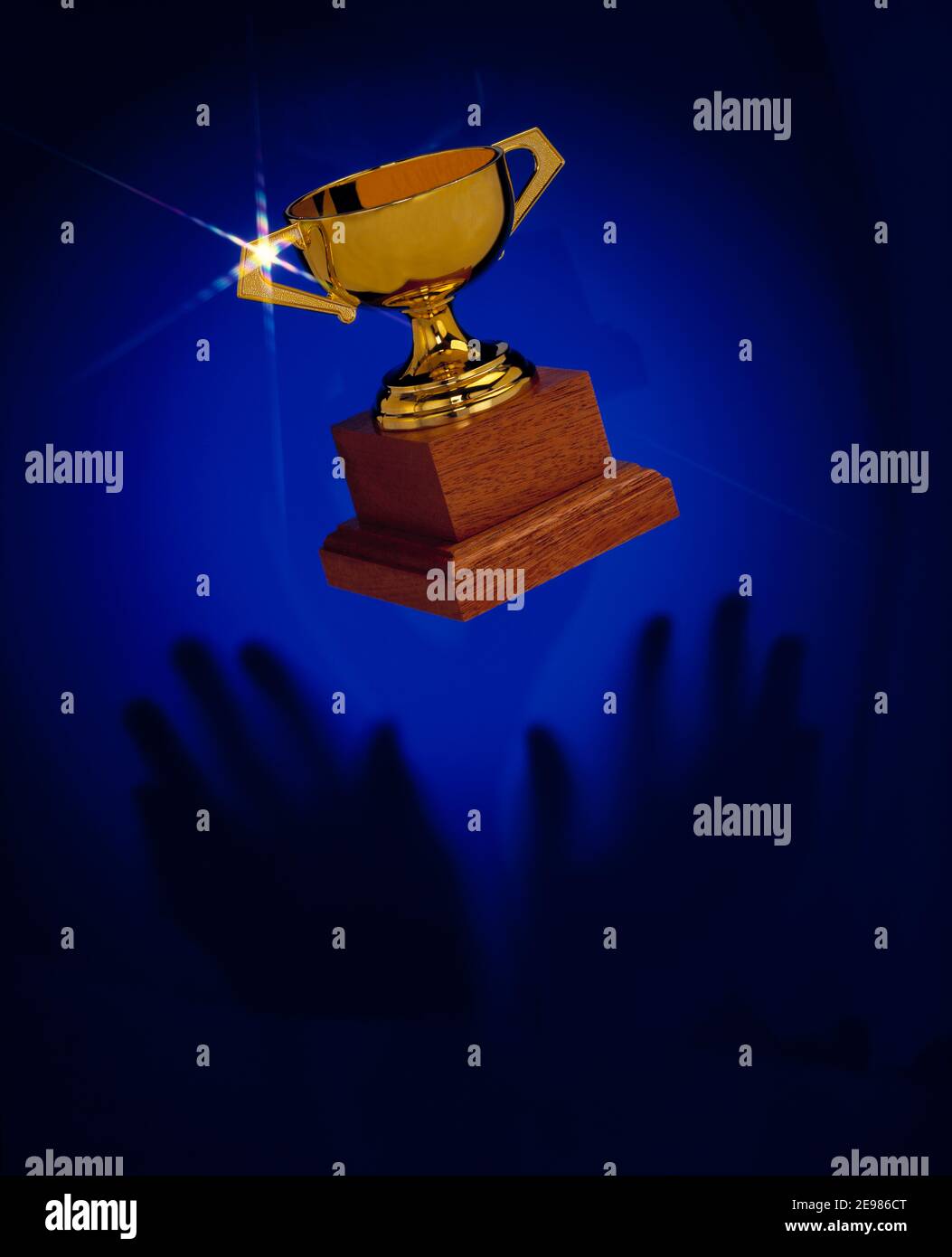 Gold trophy with Shadow hands on blue background and star burst Stock ...