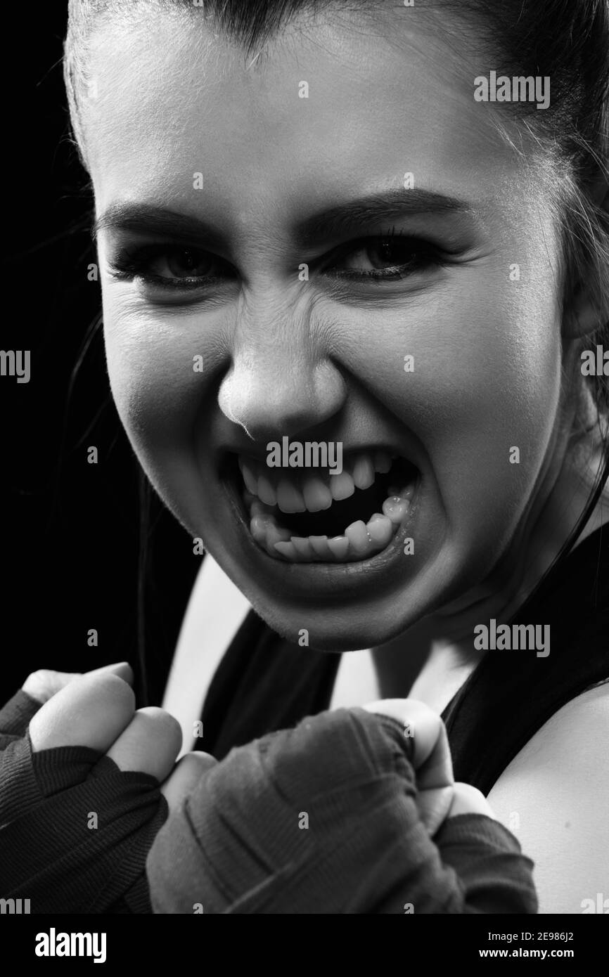 Angry Muay Thai female boxer in attack pose. Fitness young woman boxing ...