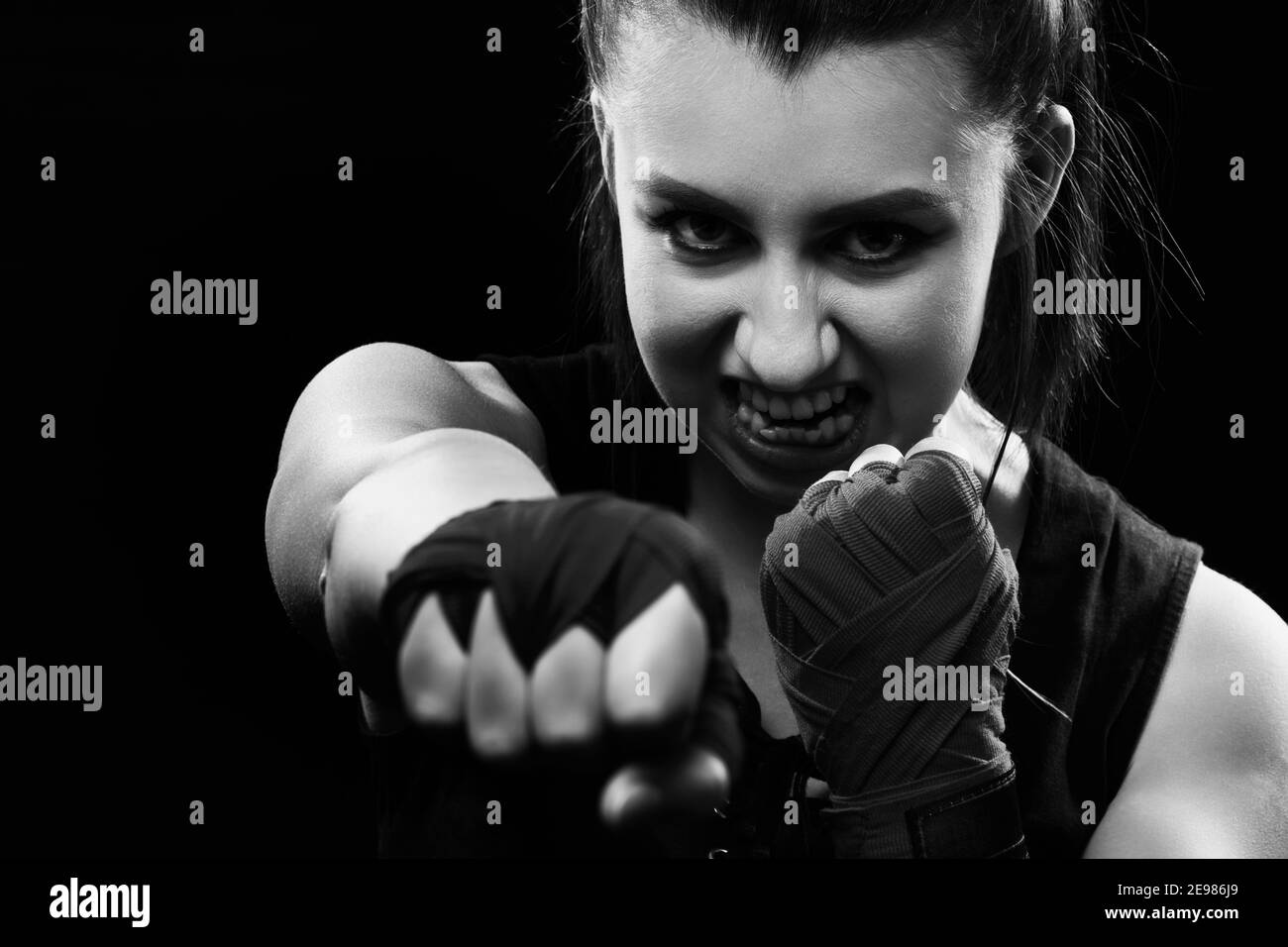 Angry Muay Thai female boxer in attack pose. Fitness young woman boxing ...