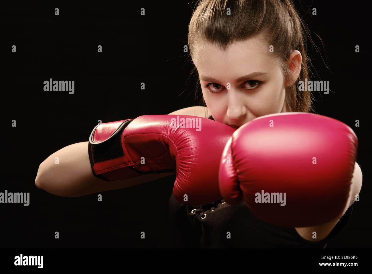 Angry Muay Thai female boxer in attack pose. Fitness young woman boxing ...