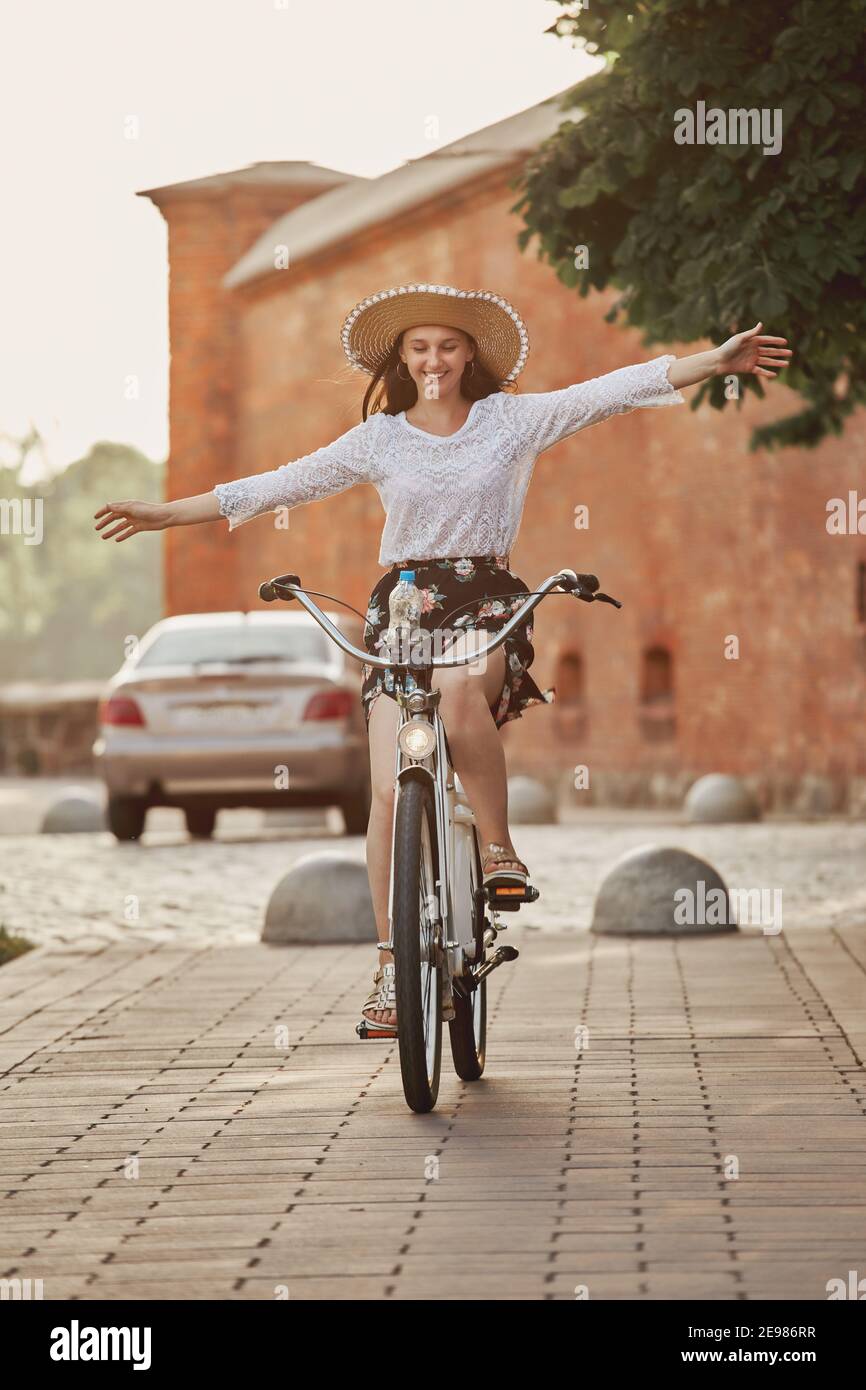 happy girl move on bike in old european city under sun rays Stock Photo ...
