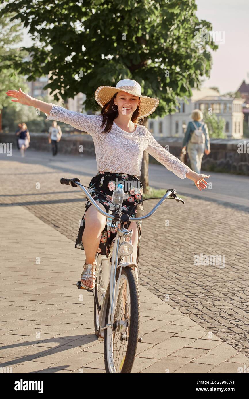 happy girl move on bike in old european city under sun rays Stock Photo ...