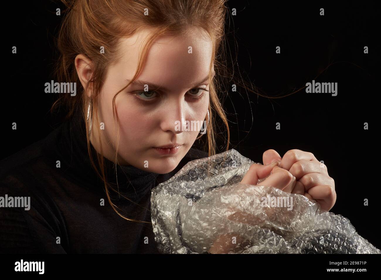 stressed woman in depression bursts bubbles of packaging cellophane ...