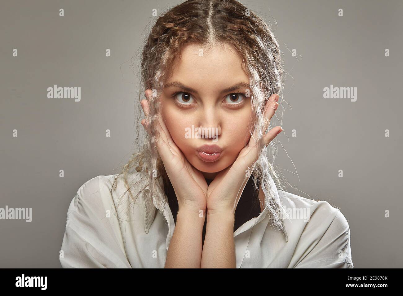 fun pretty girl on gray background making duck face Stock Photo - Alamy
