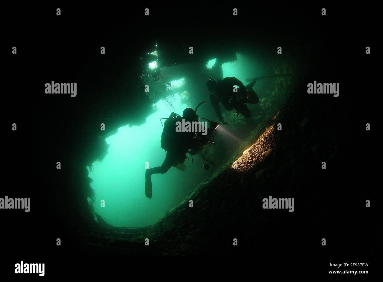 A diver illuminates part of the block ship Tabarka in Burra Sound ...