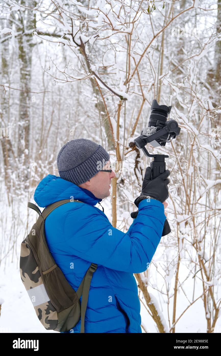 professional cameraman with camera taking shoots in snow forest Stock ...