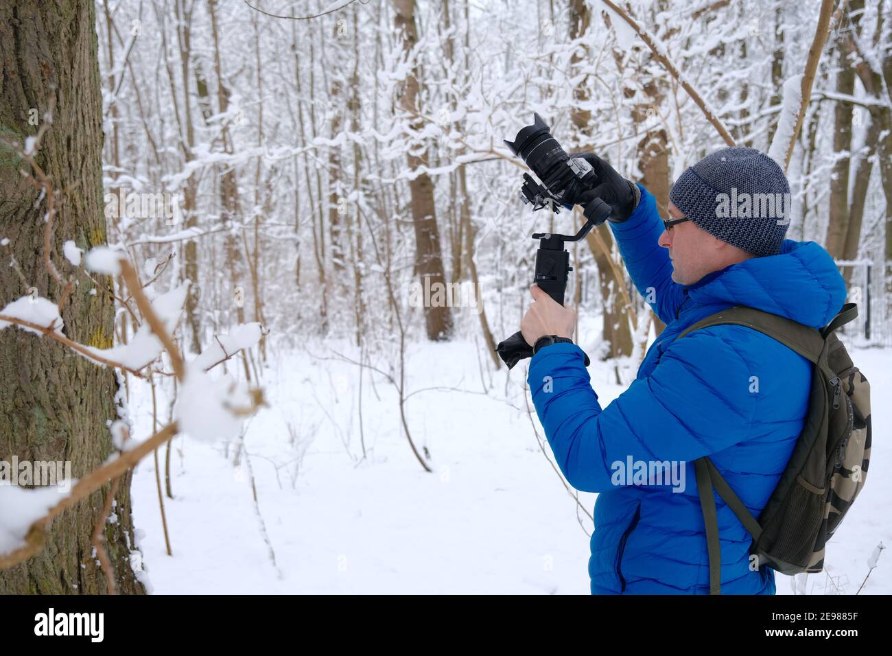 professional cameraman with camera taking shoots in snow forest Stock ...