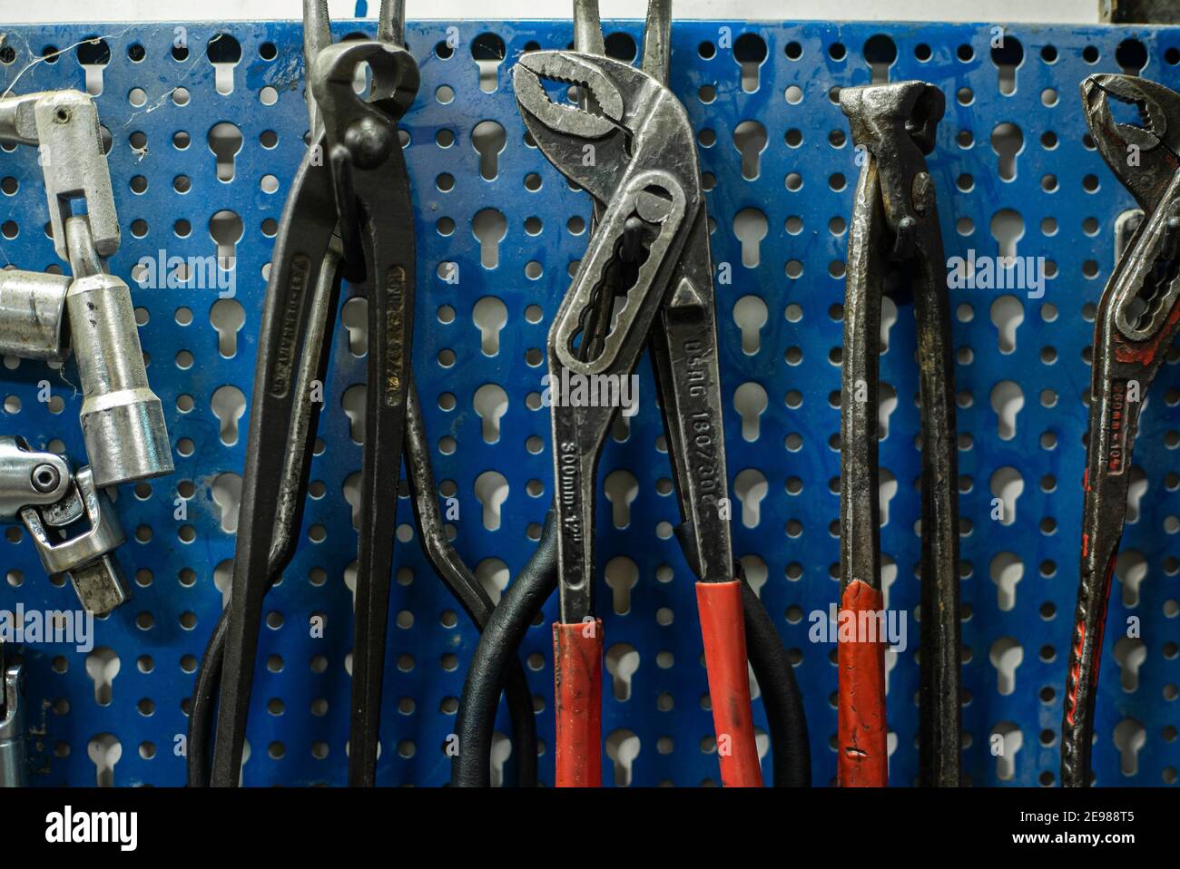 Tools hanging on the blue shelf in the mechanical workshop Stock Photo ...