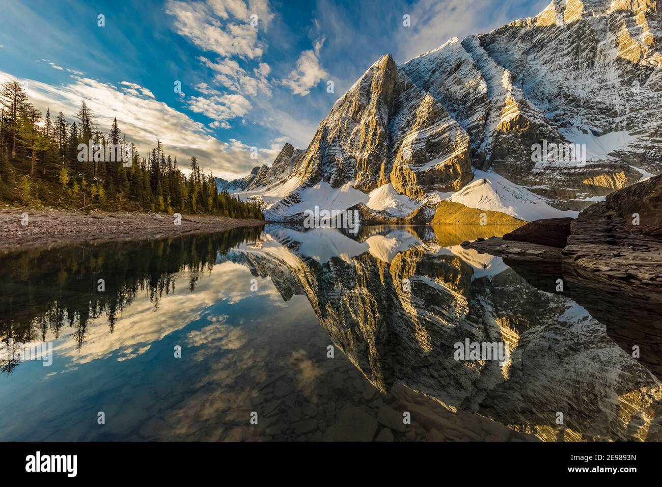 Floe Peak in morning light rising above Floe Lake in Kootenay National ...