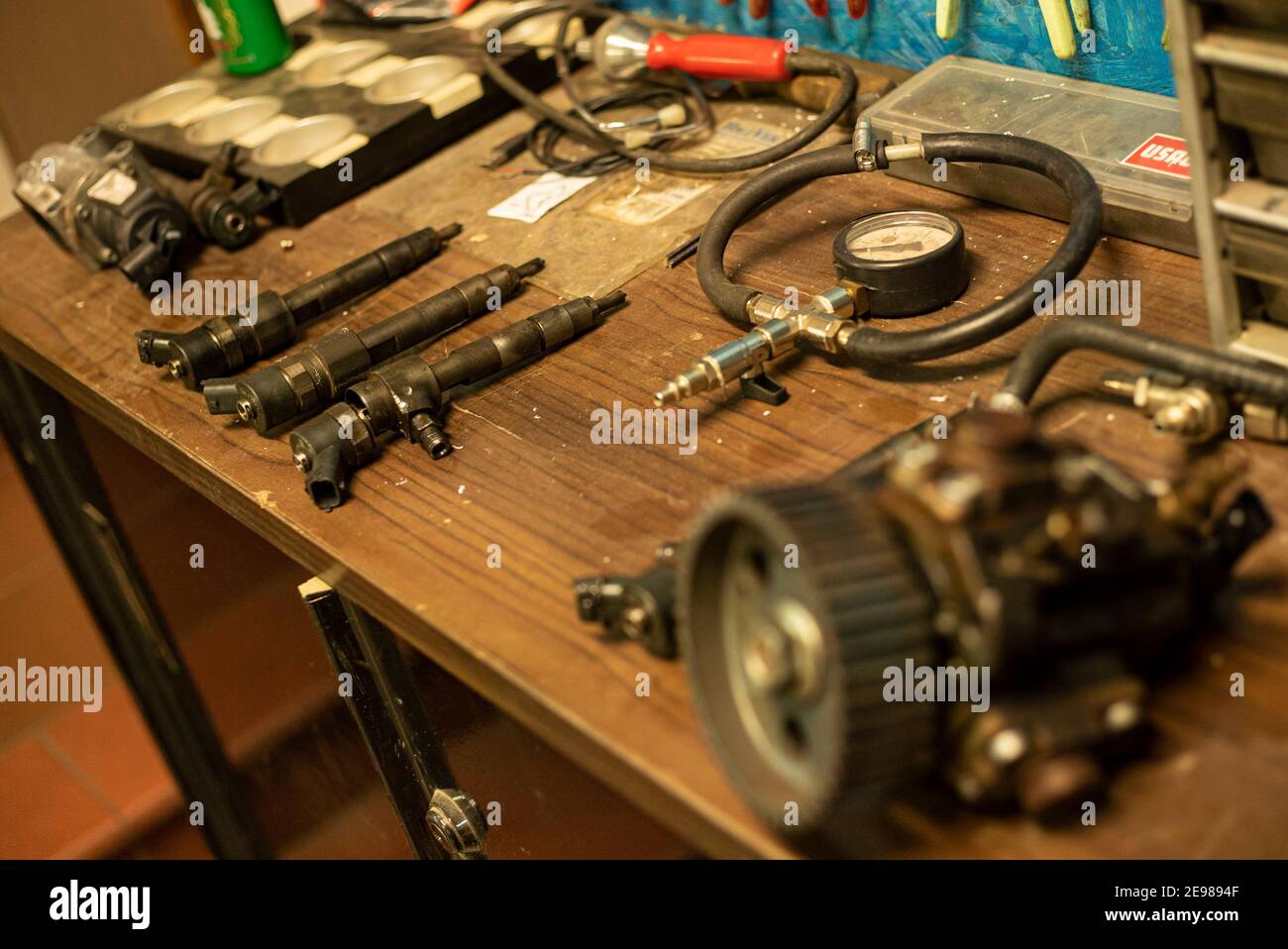 Spare car engine diesel injectors leaning on the bench of the ...