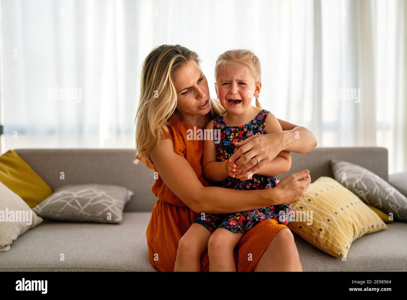 Mother comforting her crying child after she hit her hand Stock Photo - Alamy
