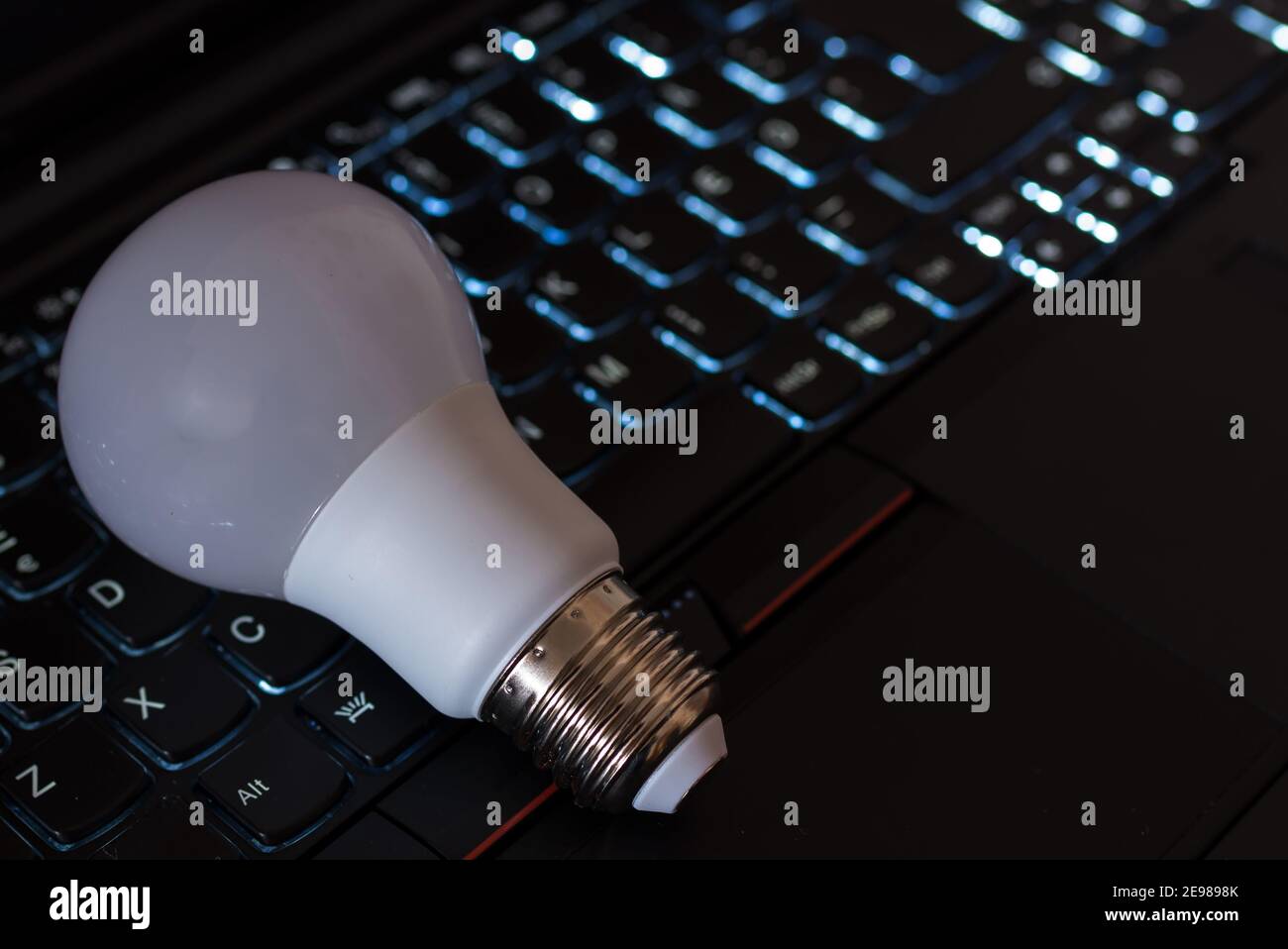 Closeup Led Bulb flat lay on keyboard background.Black dark keyboard ...
